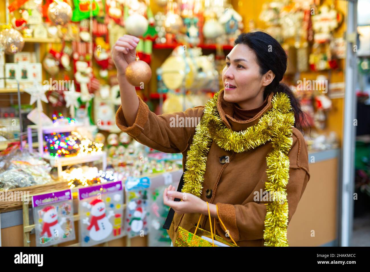 Asian female choosing decorations at Christmas fair Stock Photo - Alamy
