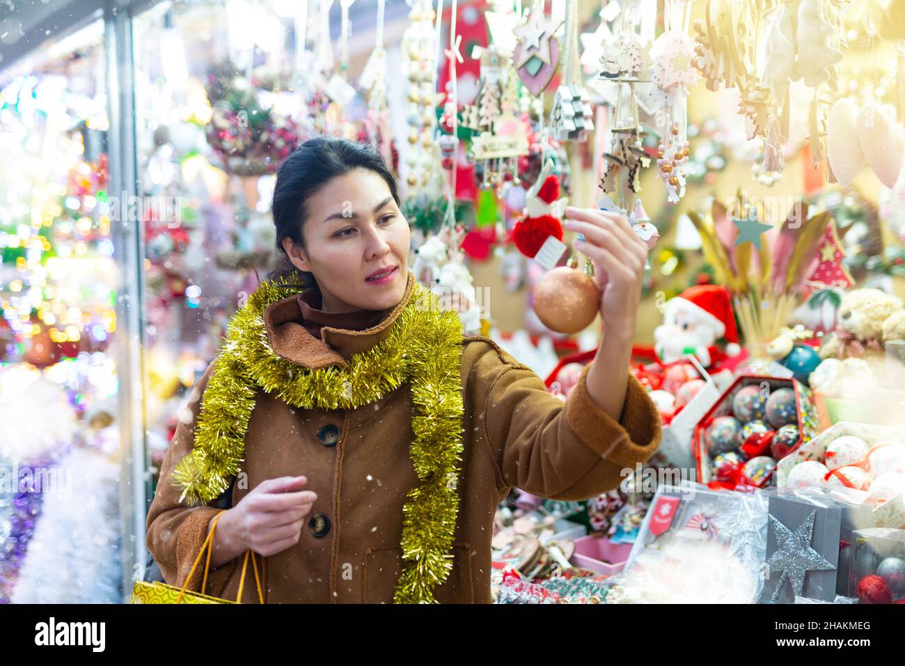 Asian female choosing decorations at Christmas fair Stock Photo - Alamy