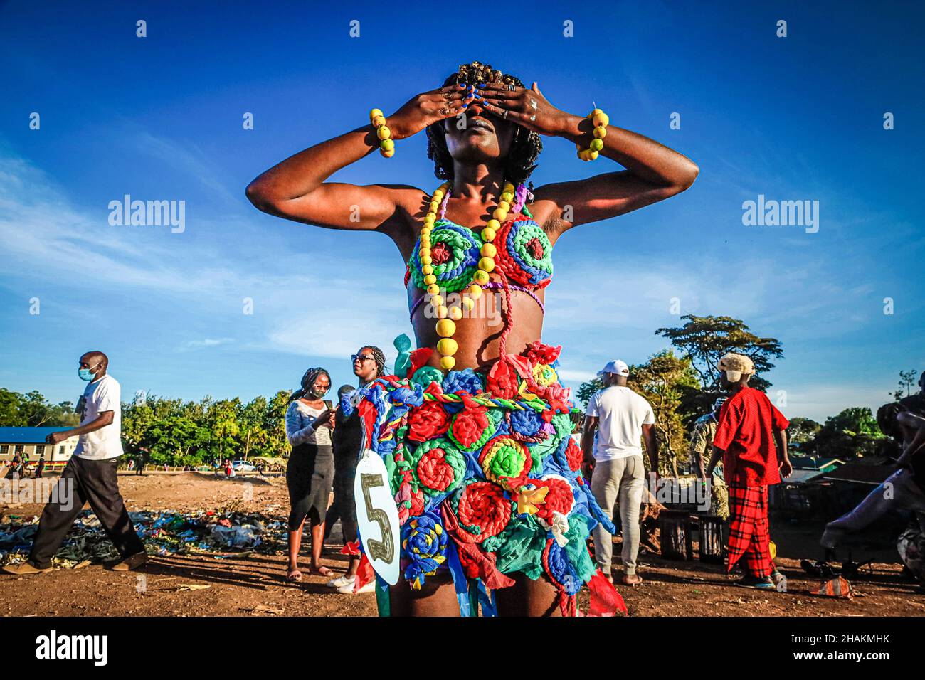 A young female model dressed in a colorful outfit poses by the streets ...