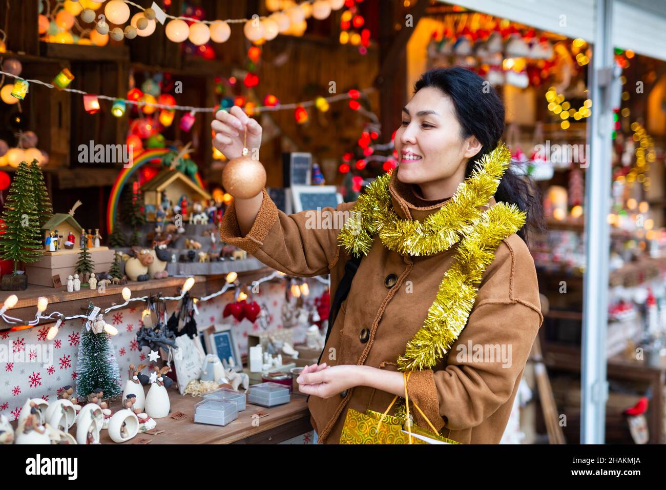 Asian female choosing decorations at Christmas fair Stock Photo - Alamy