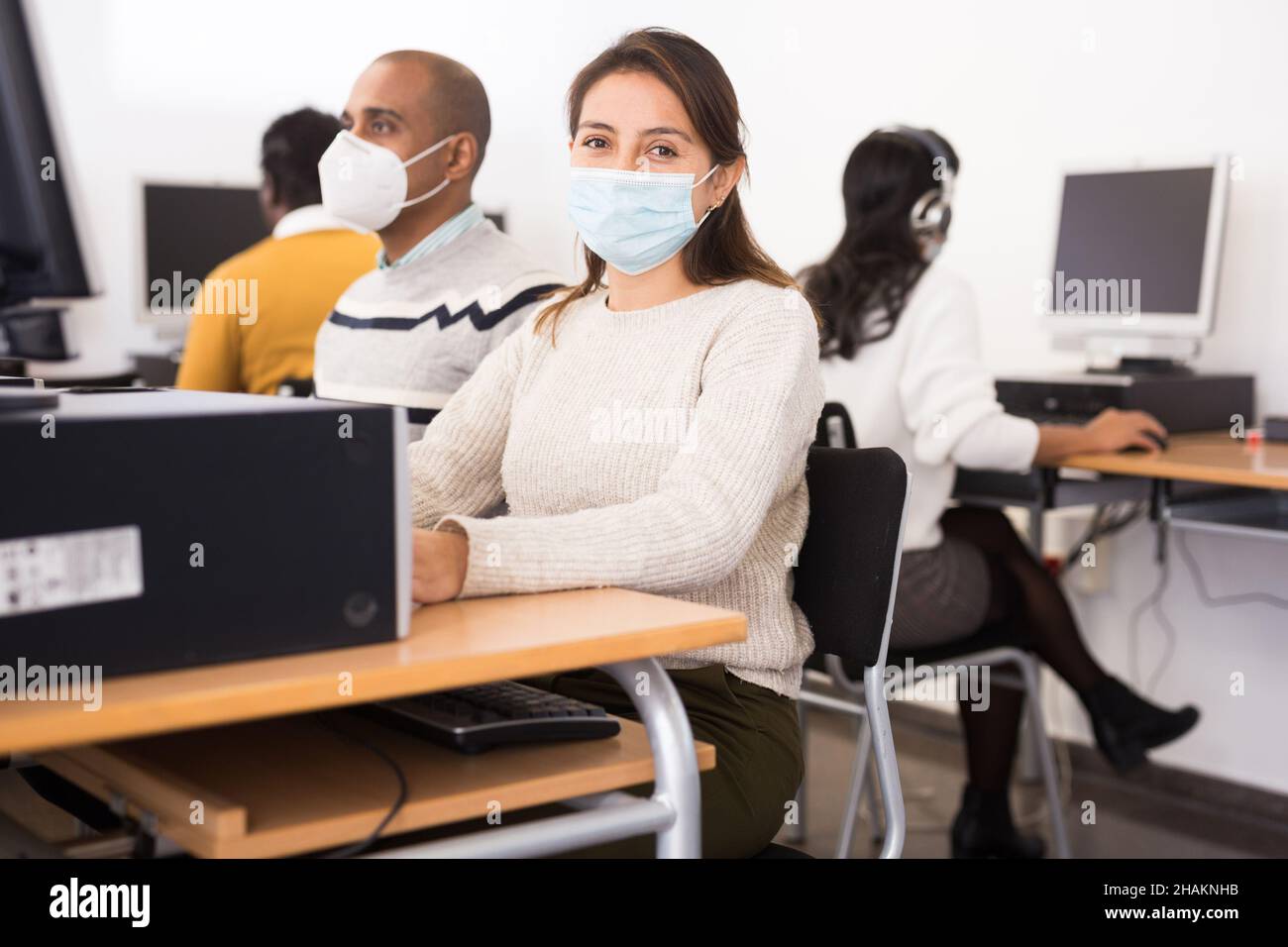 Woman in mask studying in computer class Stock Photo - Alamy
