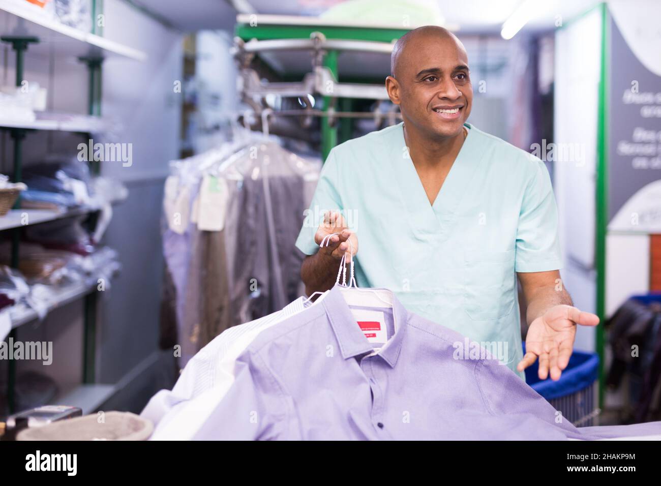Laundry male worker demonstrates clean clothes Stock Photo - Alamy