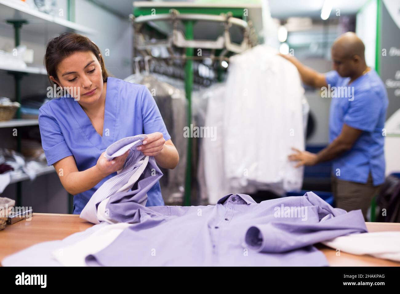 Female laundry worker checking the quality of wash Stock Photo - Alamy