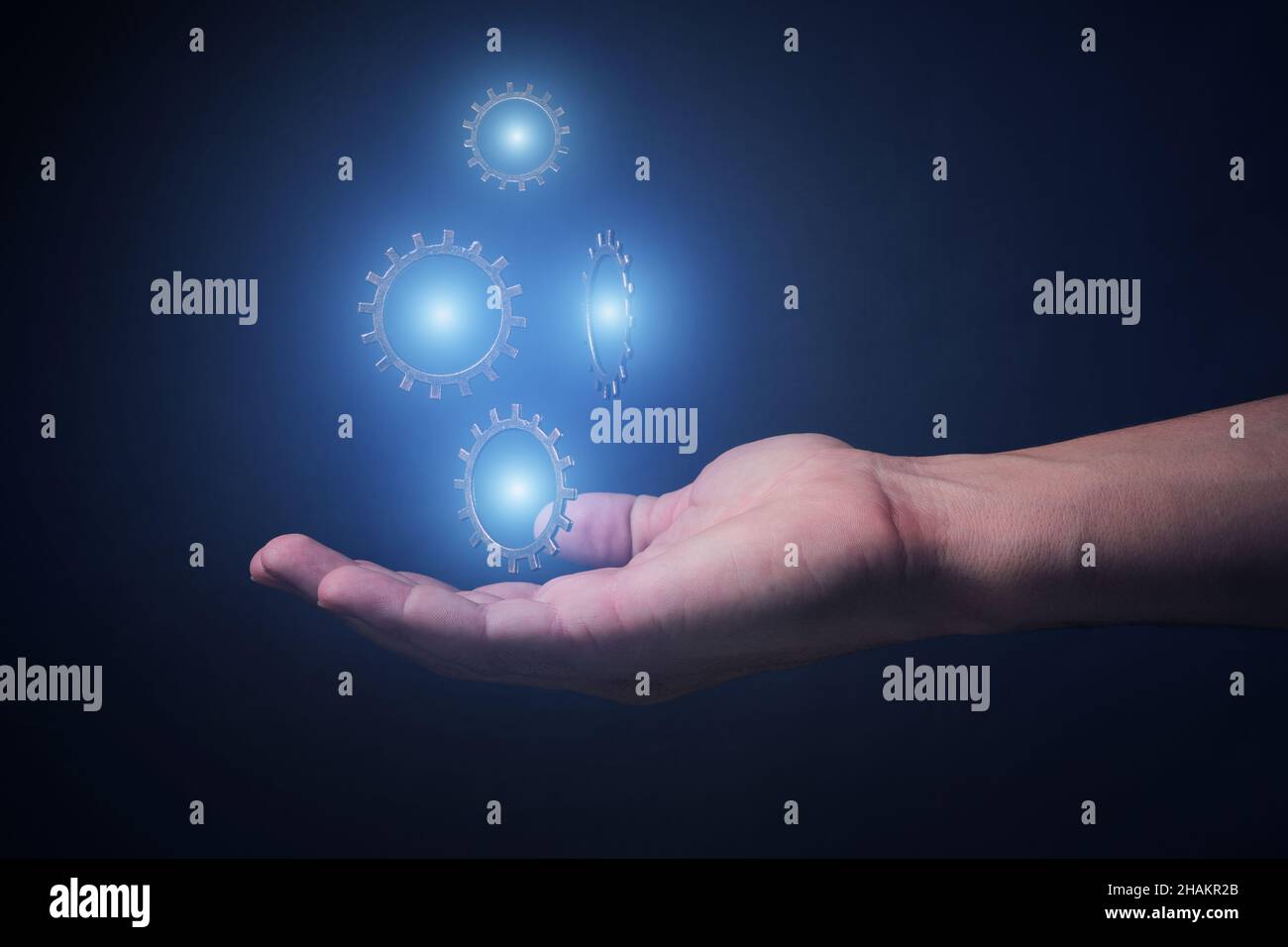 Hand and levitating glowing blue mechanisms on gray background.Concept ...