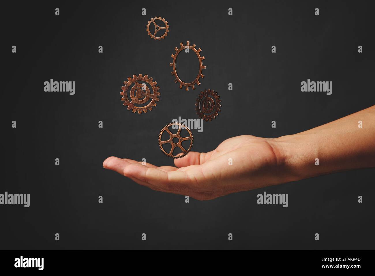 Hand and levitating gears on a gray background. Concept progress ...