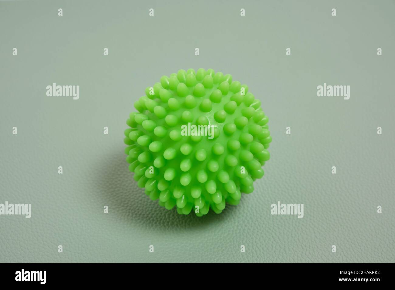 Green prickly ball on a green background Stock Photo - Alamy