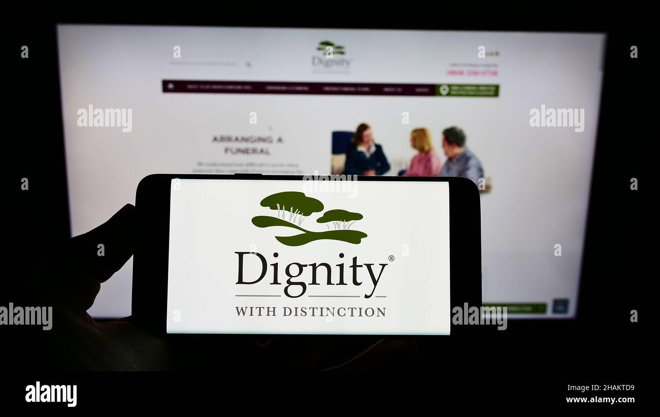 Person holding cellphone with logo of British funeral services company ...