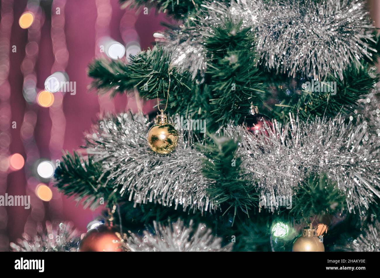The little yellow ball on the Christmas tree in shiny tinsel with ...