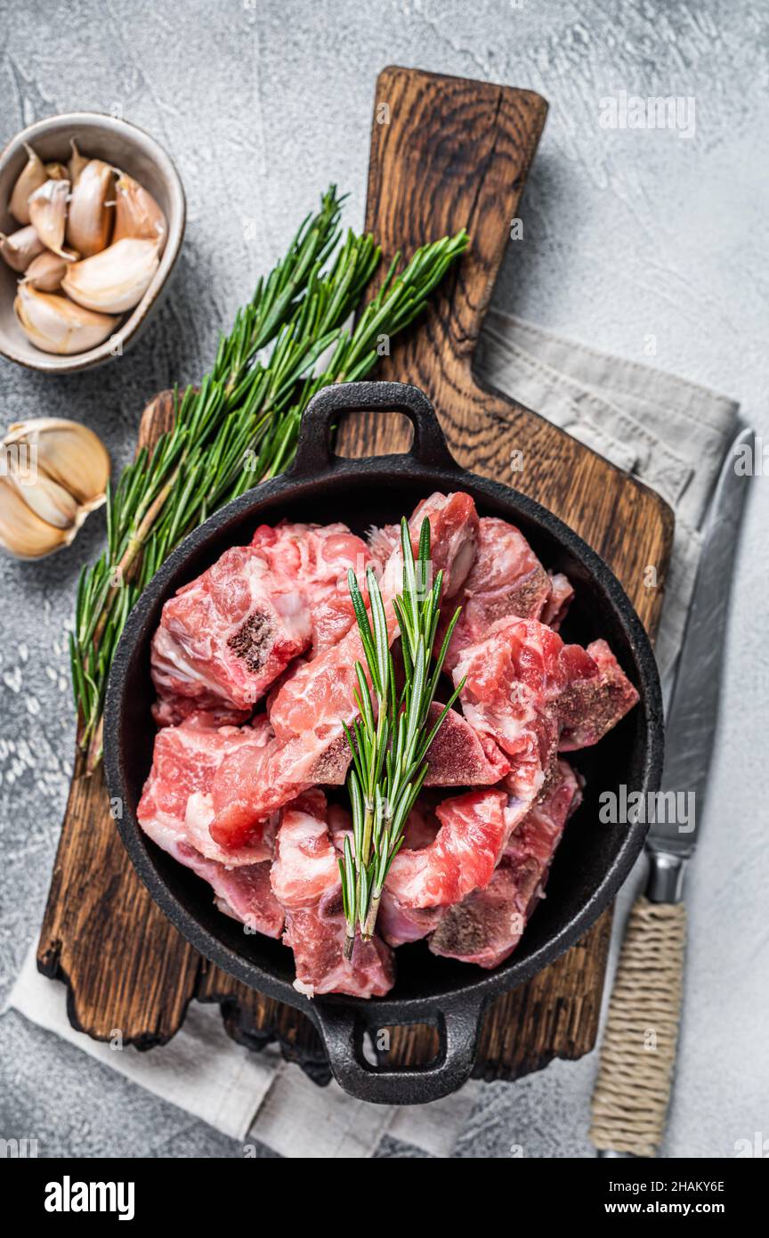 Raw diced meat cubes with bone in a pan. White background. Top View ...
