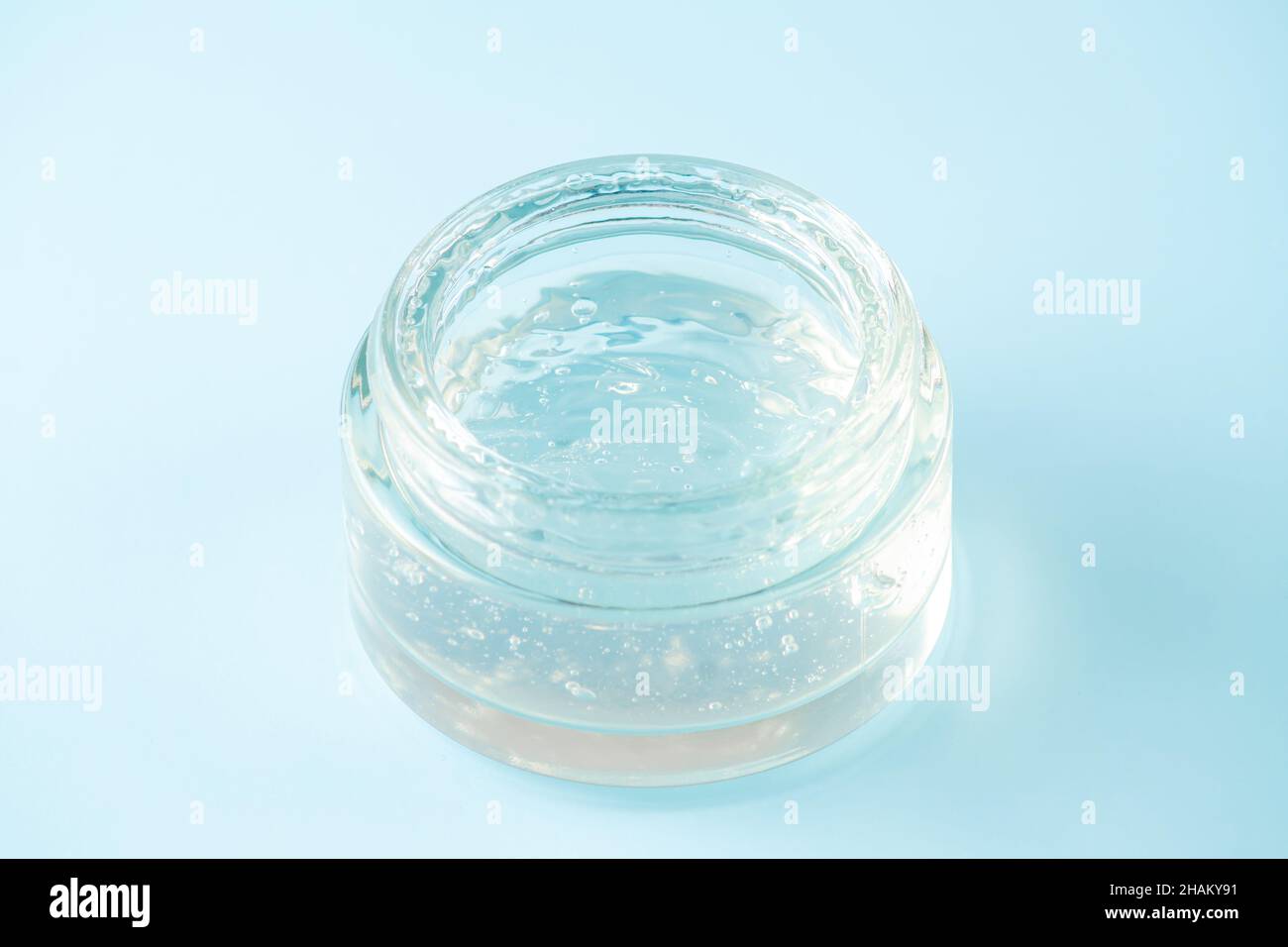 Transparent gel jar on blue background. Cosmetic gel with bubbles ...