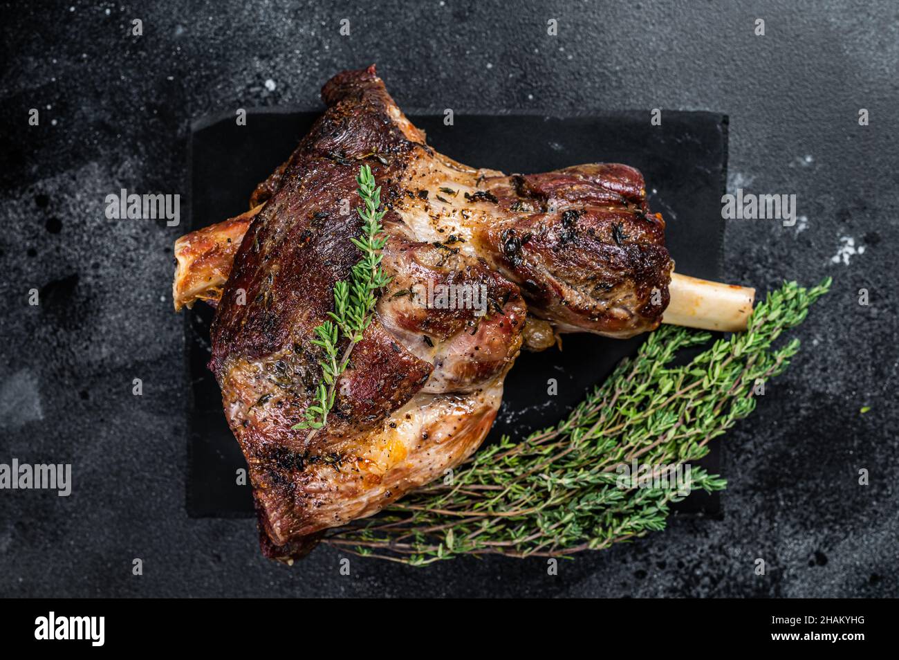 Oven Roasted lamb mutton whole leg with thyme. Black background. Top ...