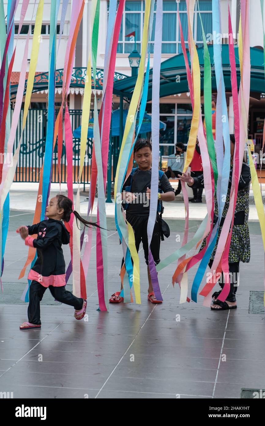 Children walking through colourful string curtains Stock Photo - Alamy