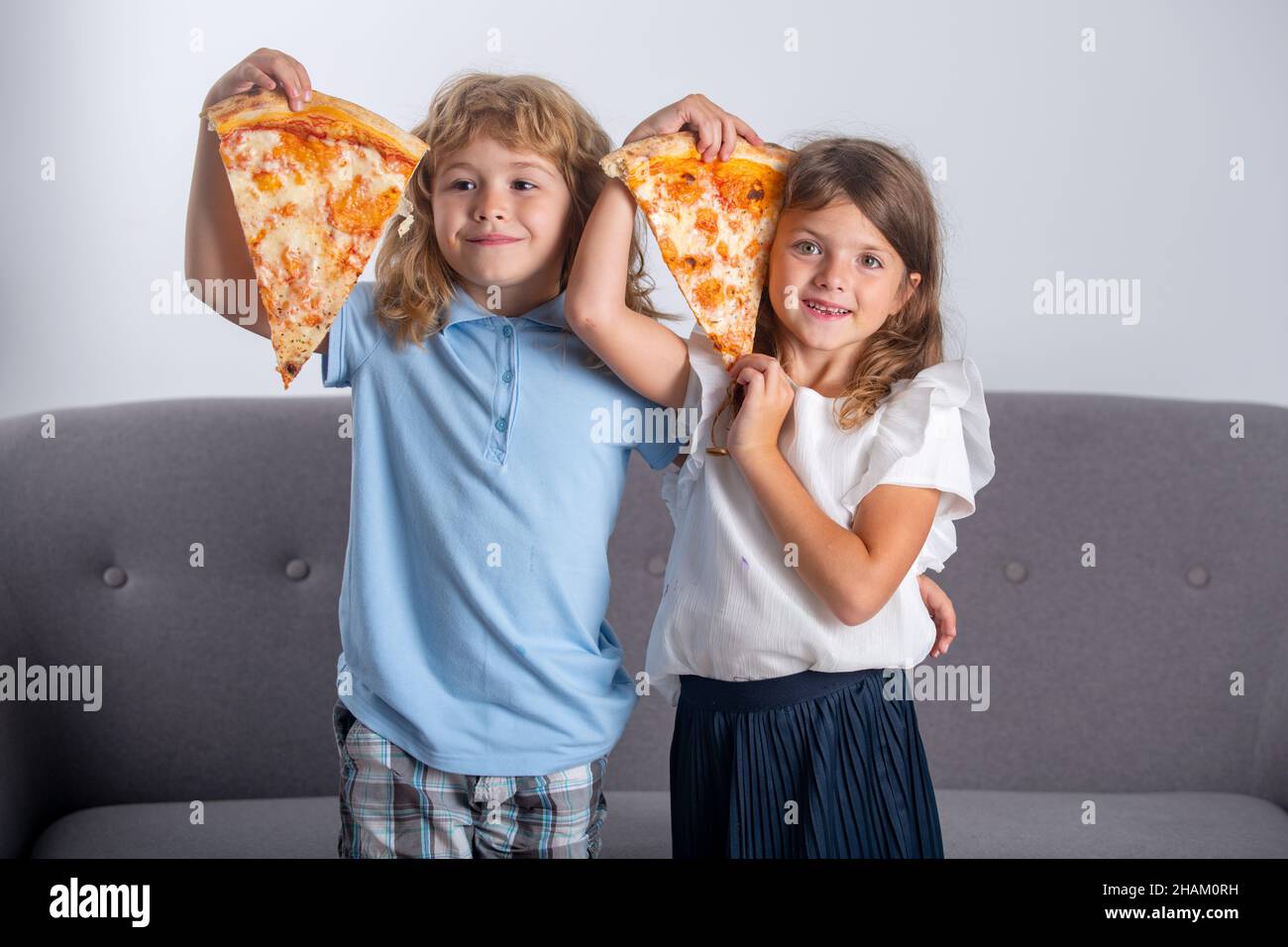 Happy daughter and son eating pizza. Children kids enjoy and having fun ...