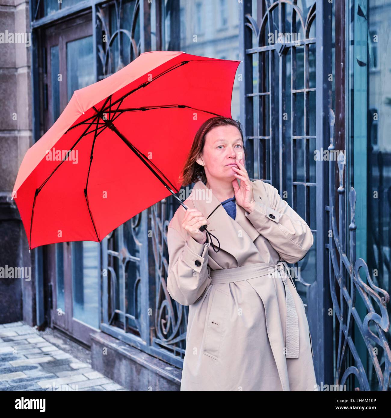 A brooding woman with a red umbrella at a vintage window Stock Photo ...