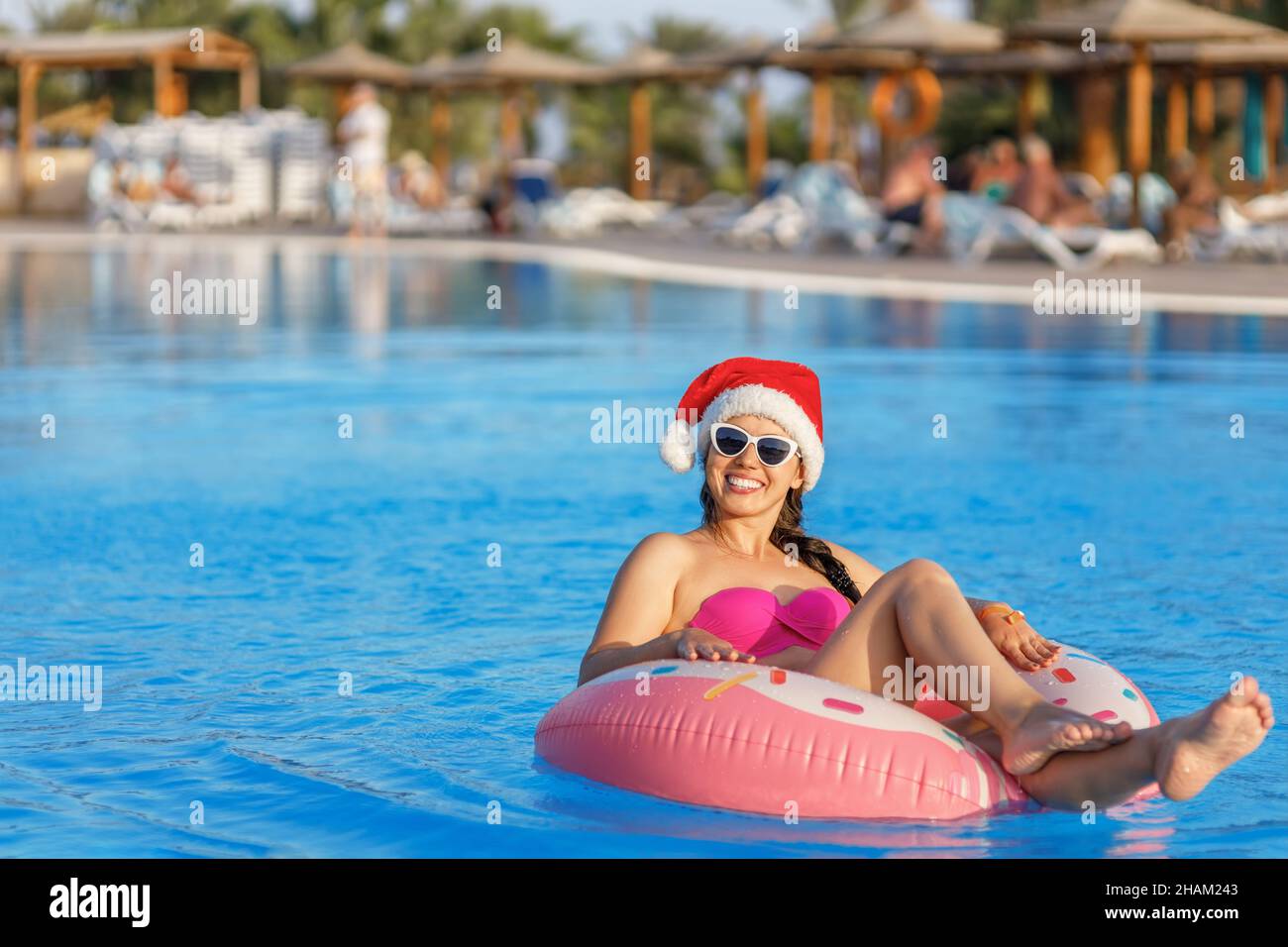 Attractive Young Woman In Santa Hat And Sunglasses Relaxing On
