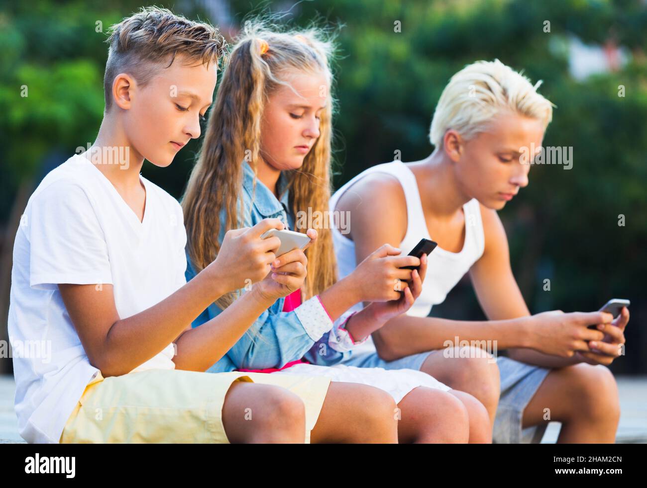 Modern kids using mobile gadgets Stock Photo - Alamy