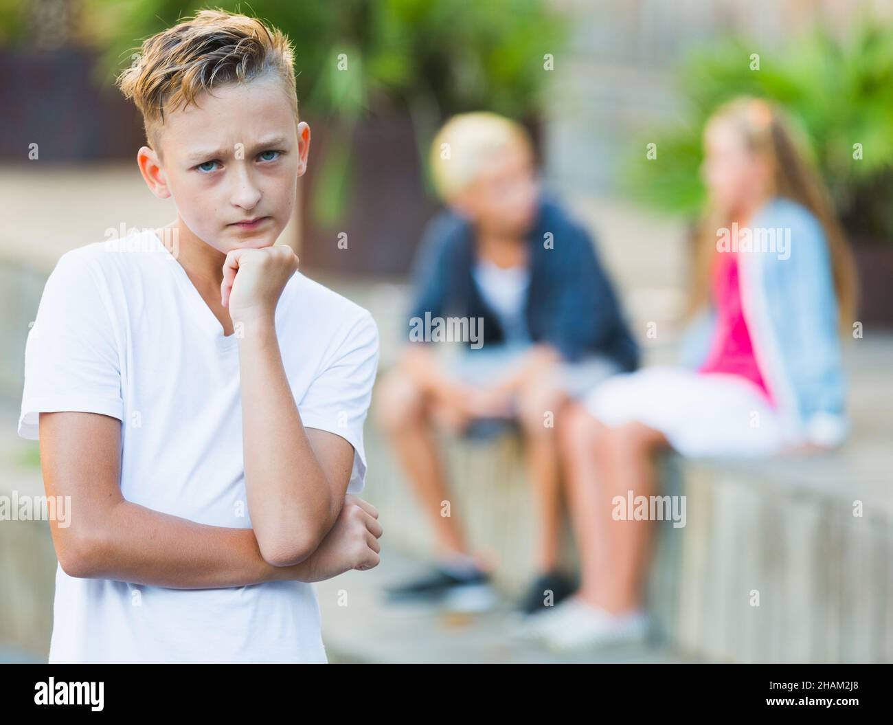 Sad boy having problems with friends Stock Photo - Alamy