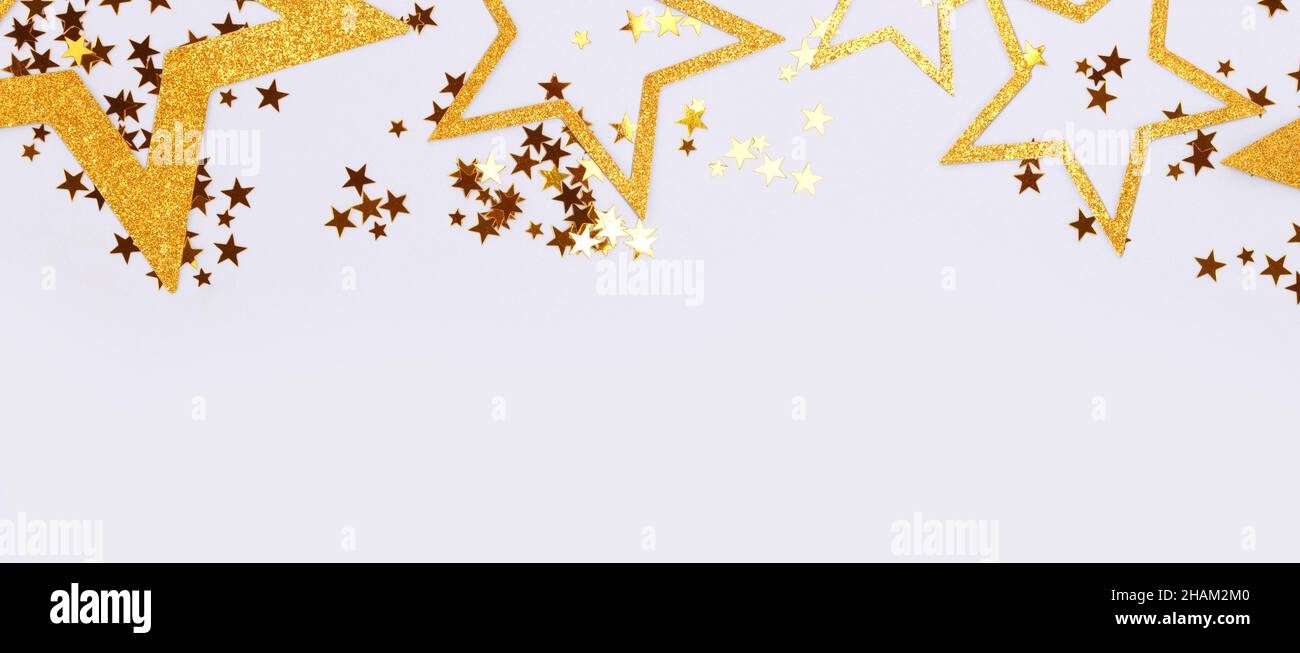 Banner with frame made of golden glittering stars confetti on a blue ...