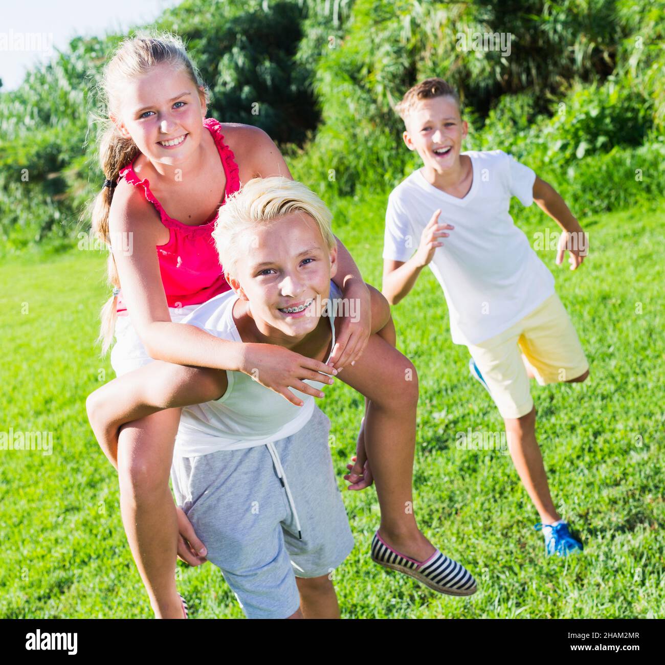 Laughing kids running on grass Stock Photo - Alamy