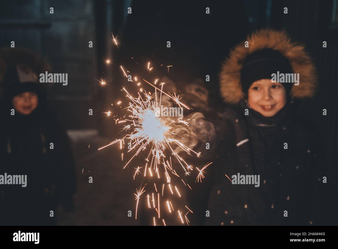 boy holds a sparkler in his hands while celebrating a new year on the ...