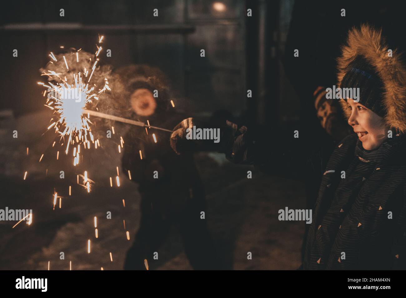 boy holds a sparkler in his hands while celebrating a new year on the ...