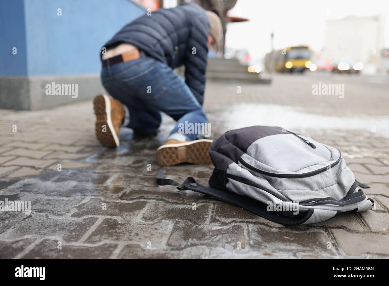 Man get up from ground after falling on slippery asphalt in winter ...