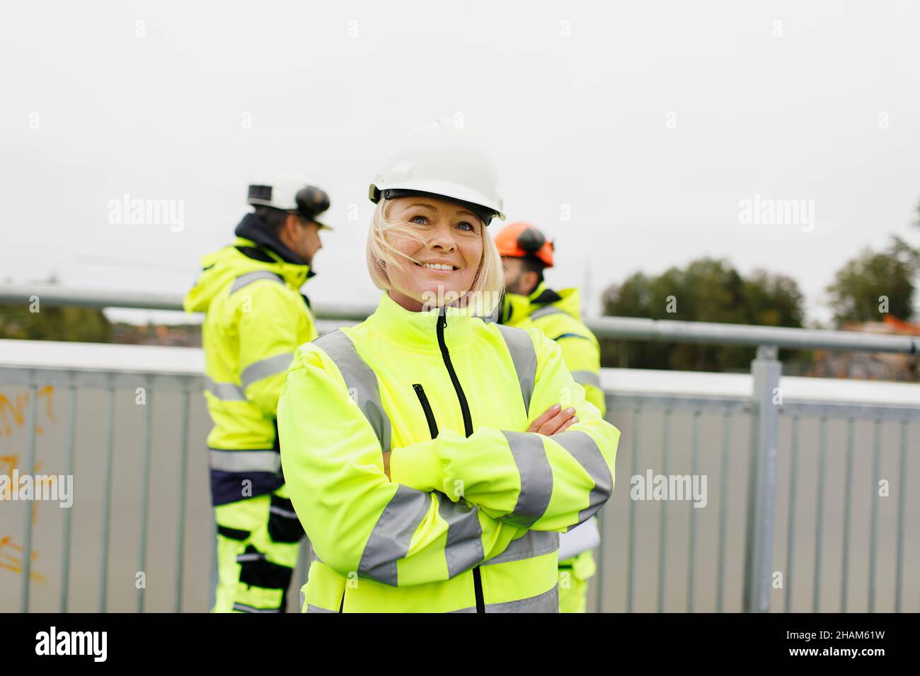 Engineers in reflective clothing standing on bridge Stock Photo - Alamy
