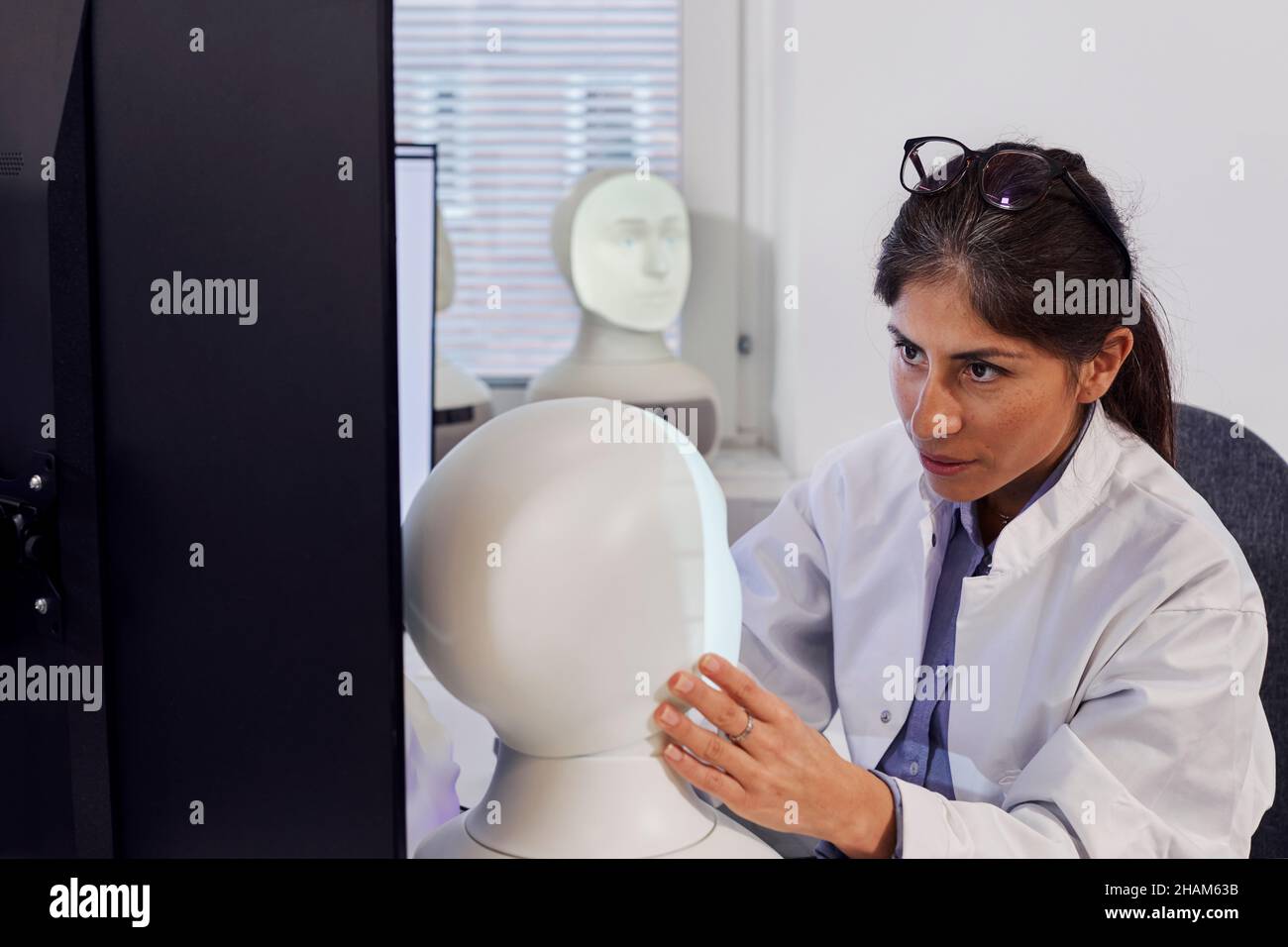 Female engineer building robot at work station Stock Photo - Alamy