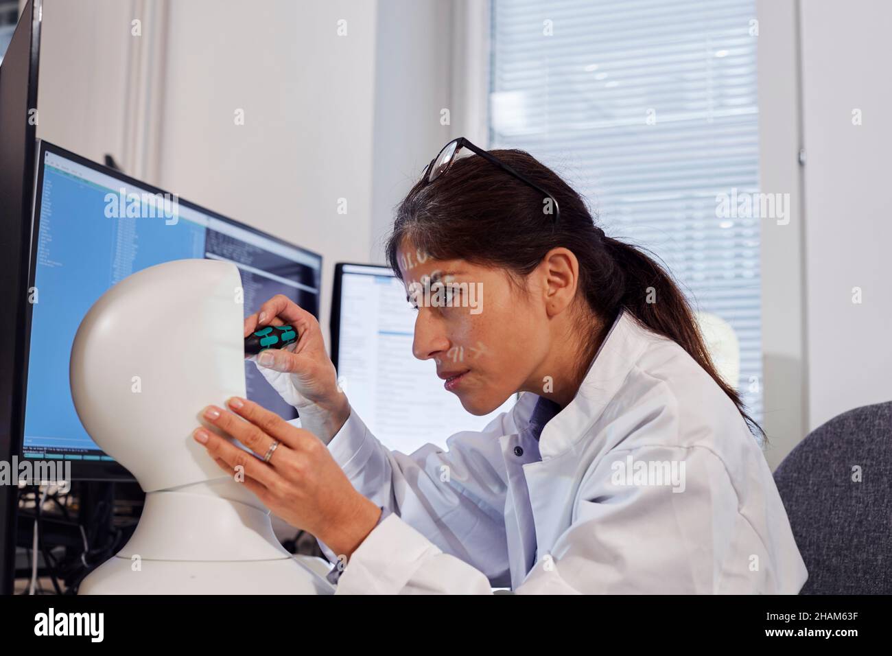 Female engineer building robot at work station Stock Photo - Alamy