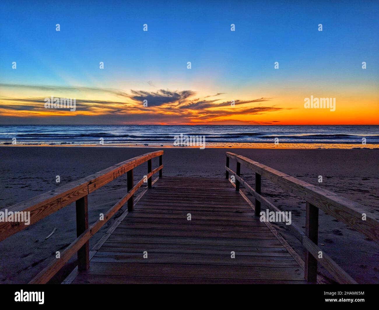 Beautiful scenery of a boardwalk in the seashore with a sunset ...