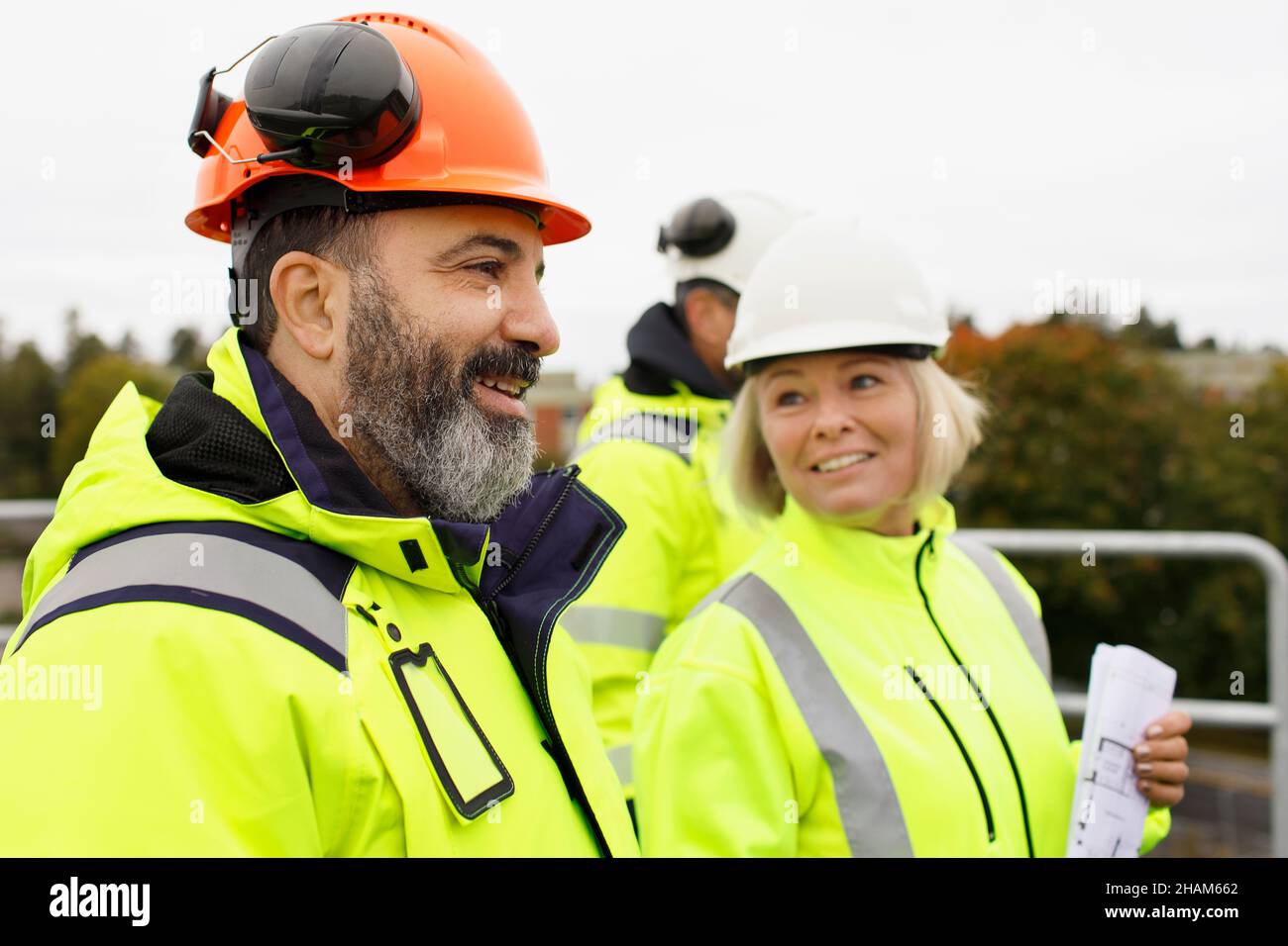 Engineers in reflective clothing talking Stock Photo - Alamy