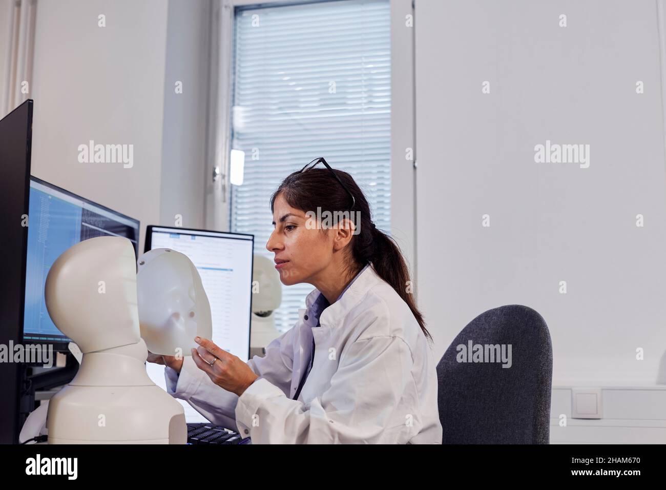 Female engineer building robot at work station Stock Photo - Alamy