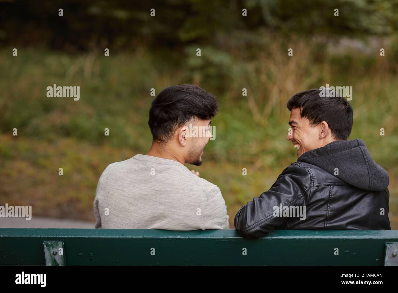 Rear view of men sitting on bench Stock Photo - Alamy