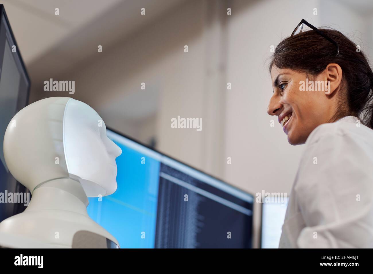 Smiling female engineer building robot Stock Photo - Alamy