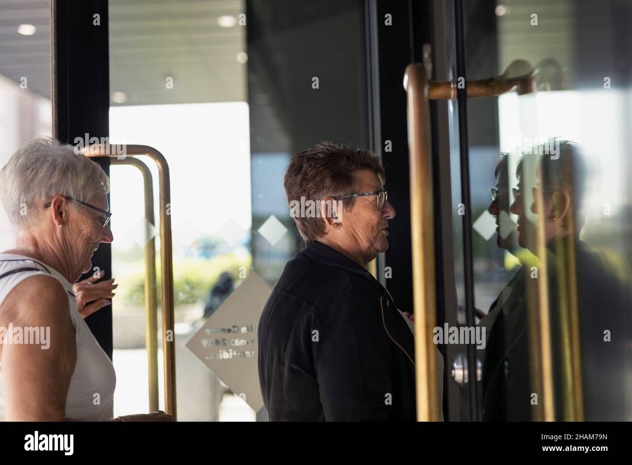 Senior women entering shop Stock Photo - Alamy