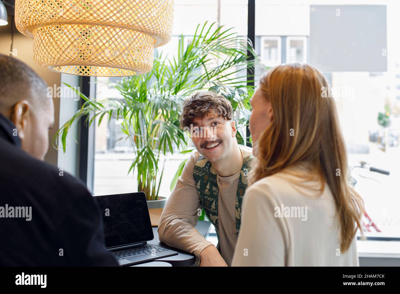 Young coworkers talking together Stock Photo - Alamy