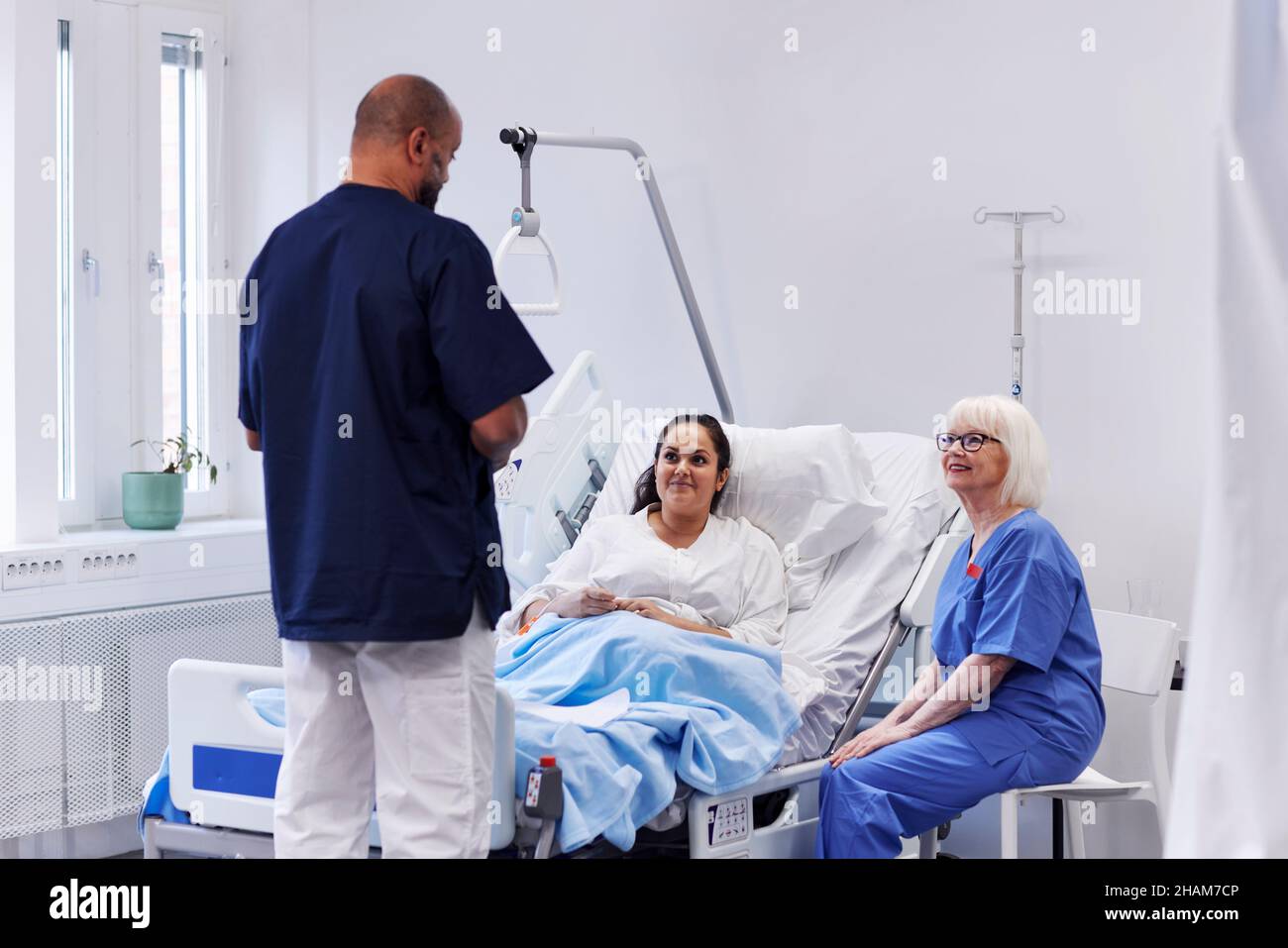 Female patient on hospital bed talking to nurse Stock Photo - Alamy