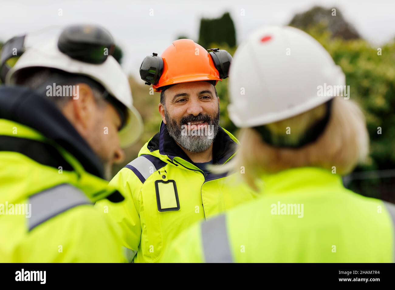 Engineers in reflective clothing talking Stock Photo - Alamy