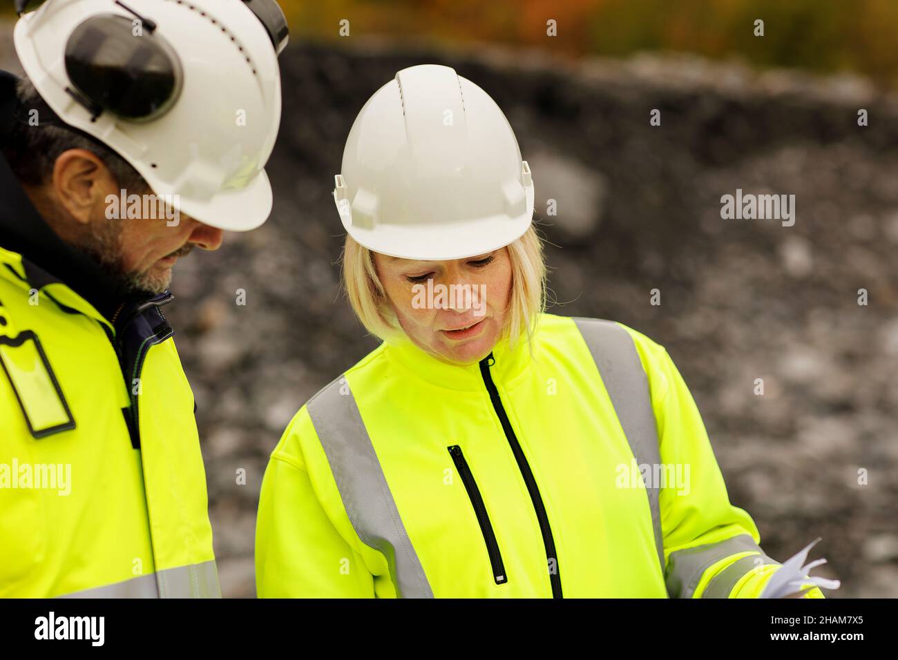 Engineers in reflective clothing looking at plans Stock Photo - Alamy