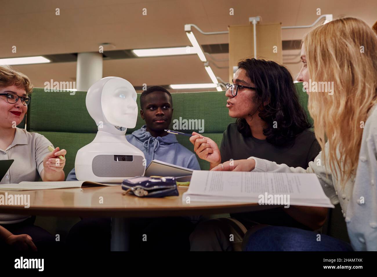 Friends sitting together in library Stock Photo - Alamy