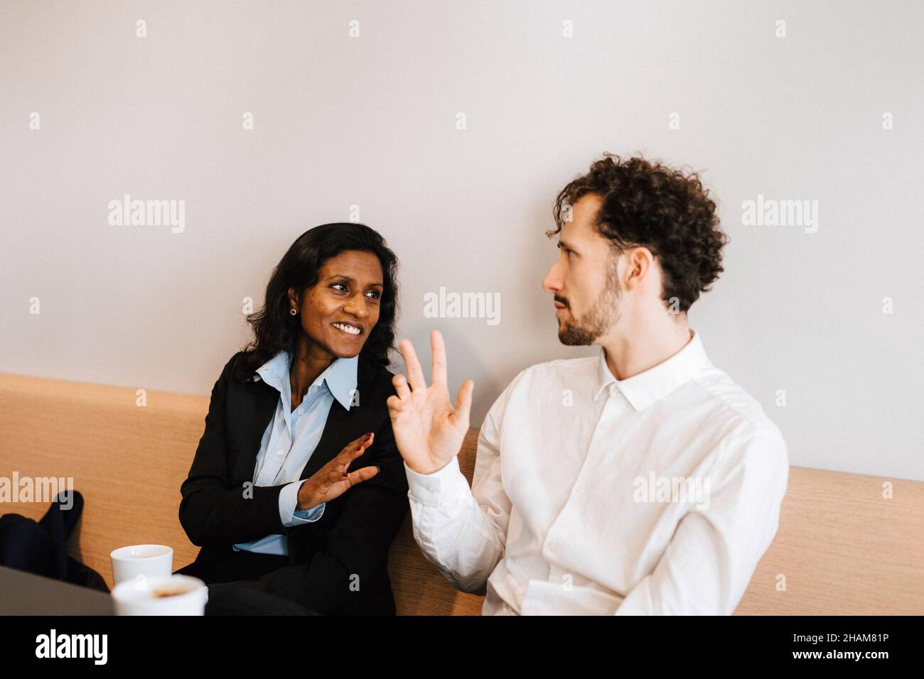 Coworkers talking to each other Stock Photo - Alamy