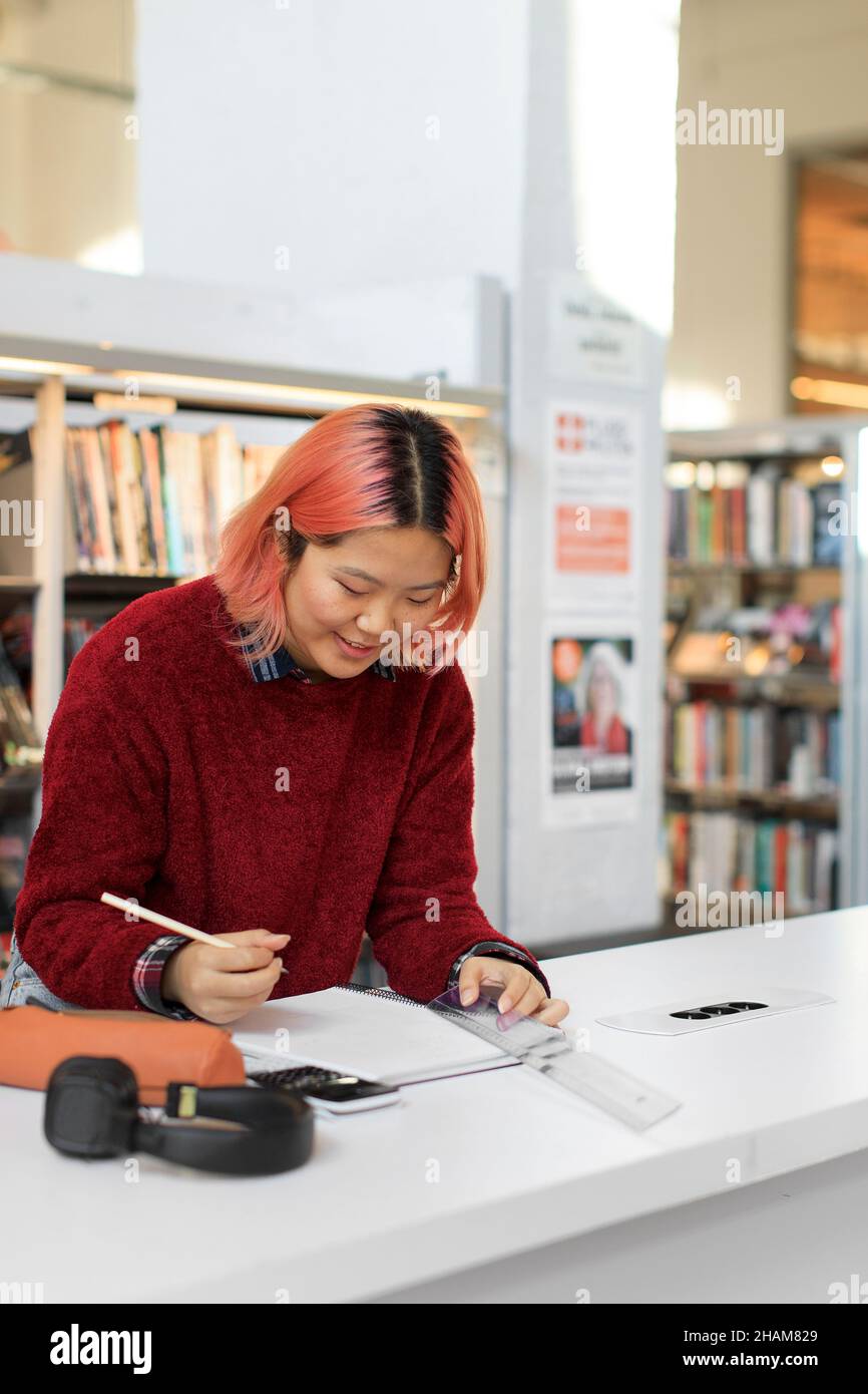 Smiling student working library hi-res stock photography and images - Alamy