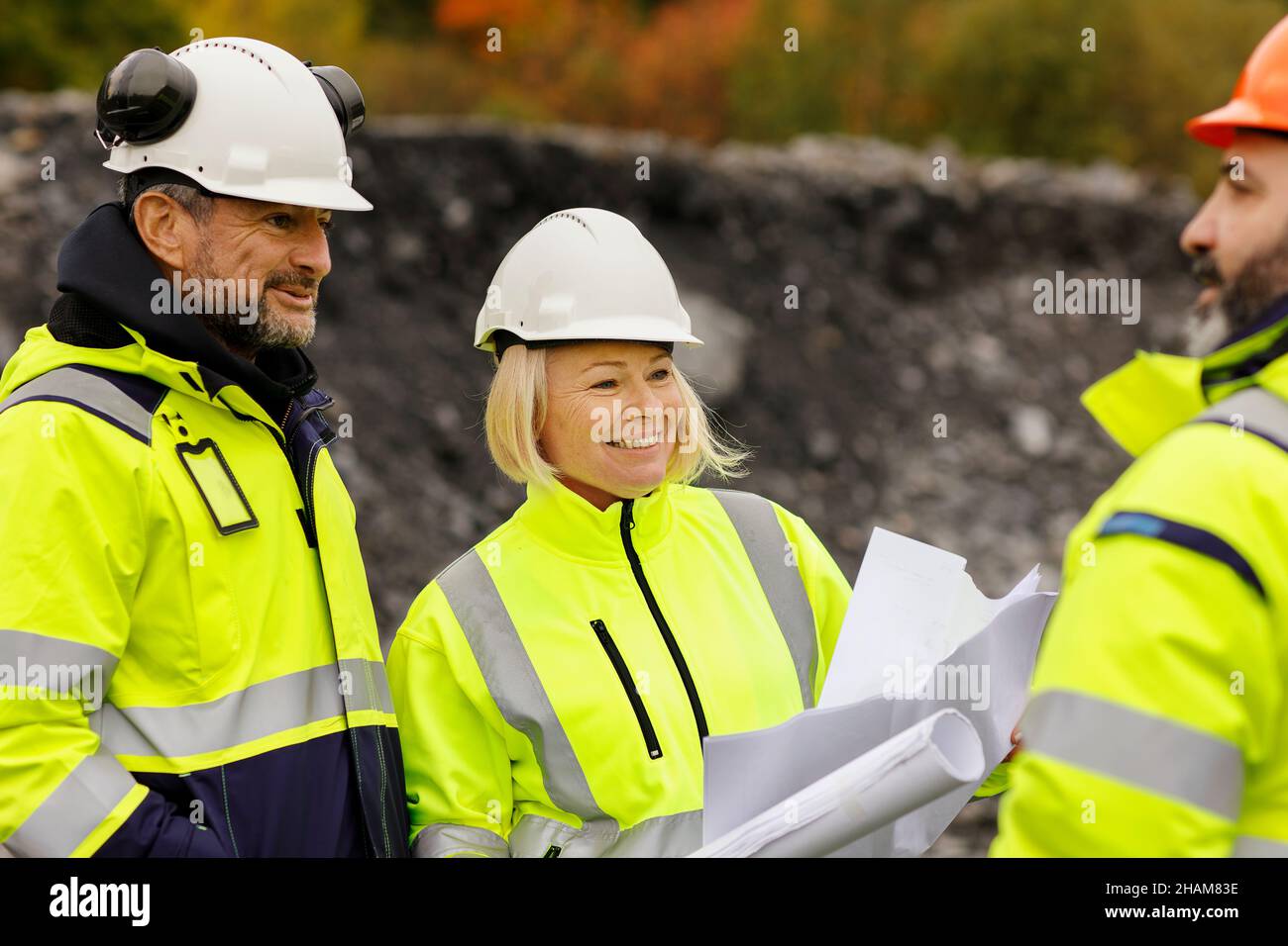 Engineers in reflective clothing looking at plans Stock Photo - Alamy