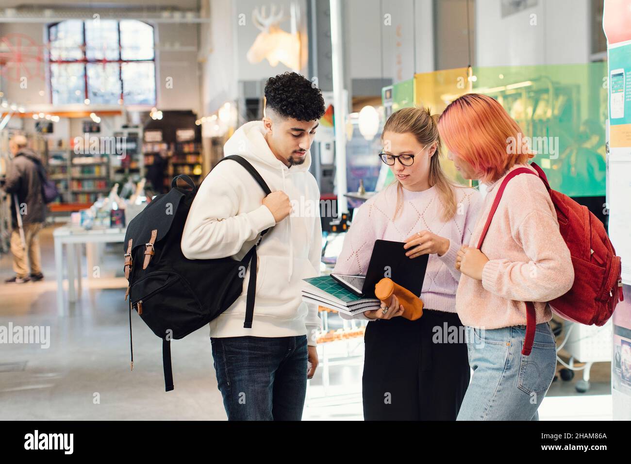 Young friends in library Stock Photo - Alamy