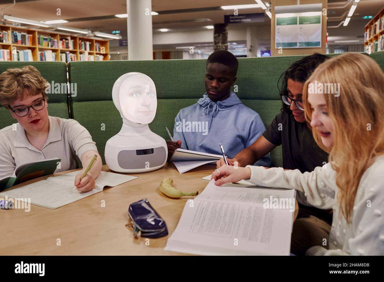 Friends sitting together in library Stock Photo - Alamy