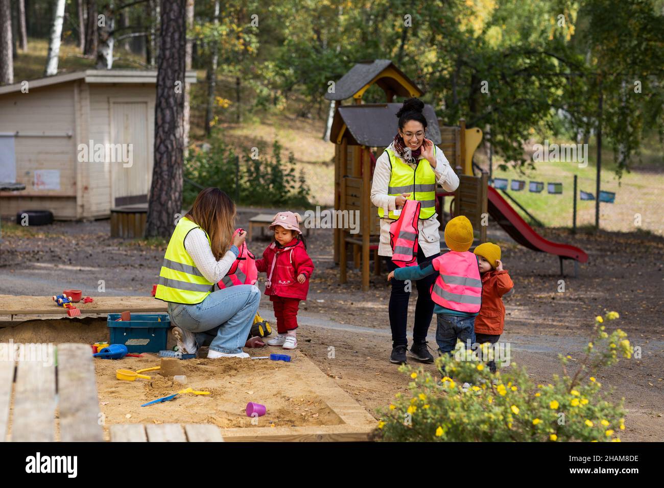 Preschool teachers with students at playground Stock Photo - Alamy