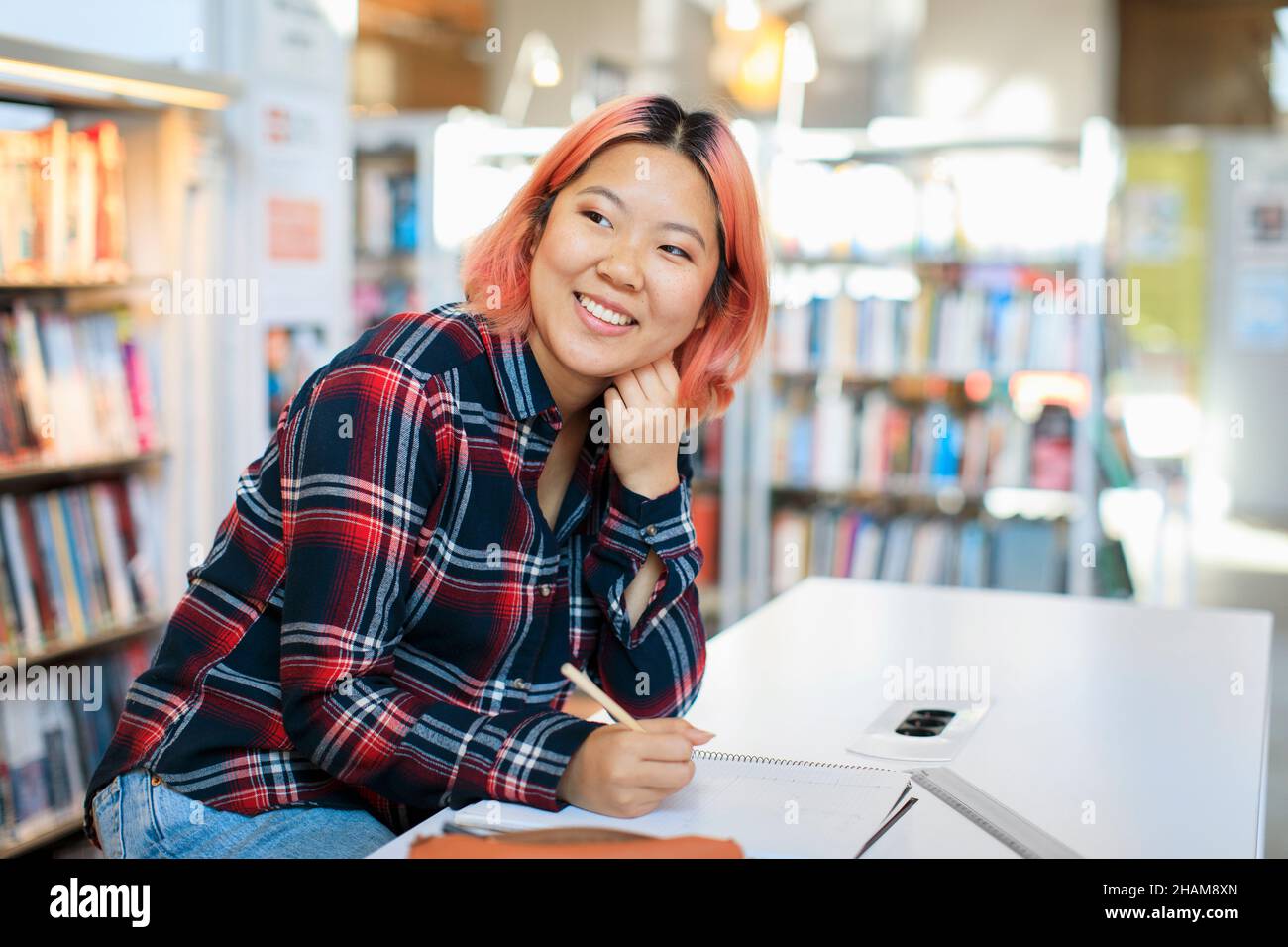 Young woman studying in library Stock Photo - Alamy
