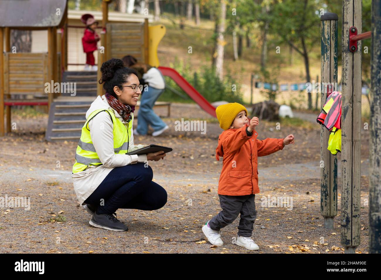 Preschool teacher with student at playground Stock Photo - Alamy