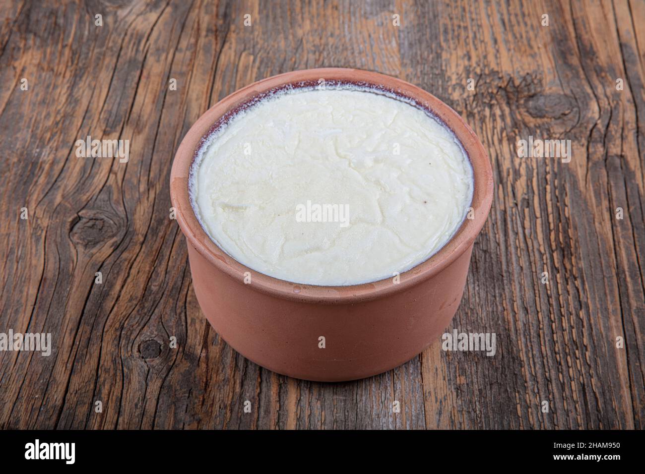 Natural,yogurt in casserole bowl on wooden table with spoon.Close up ...