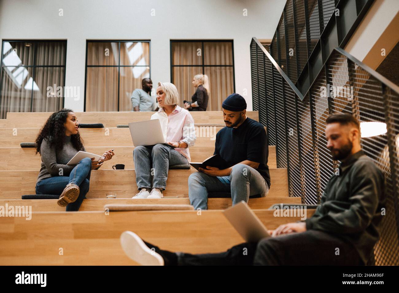 People relaxing on stairs in office building Stock Photo - Alamy